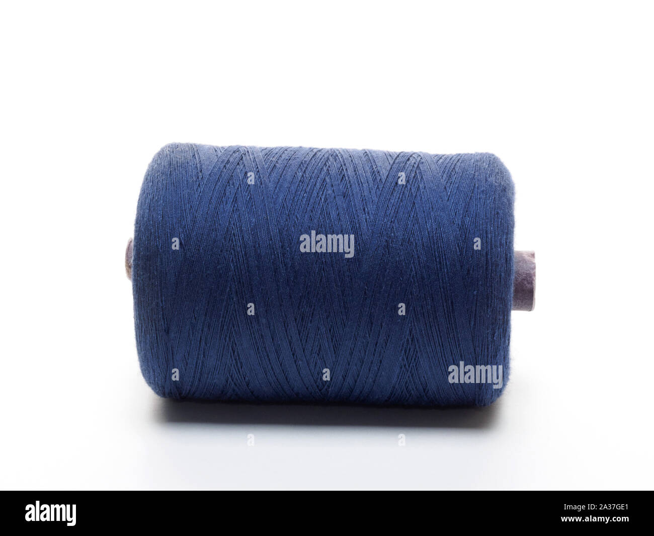 Blue spool of thread in a horizontal position on a white background ...