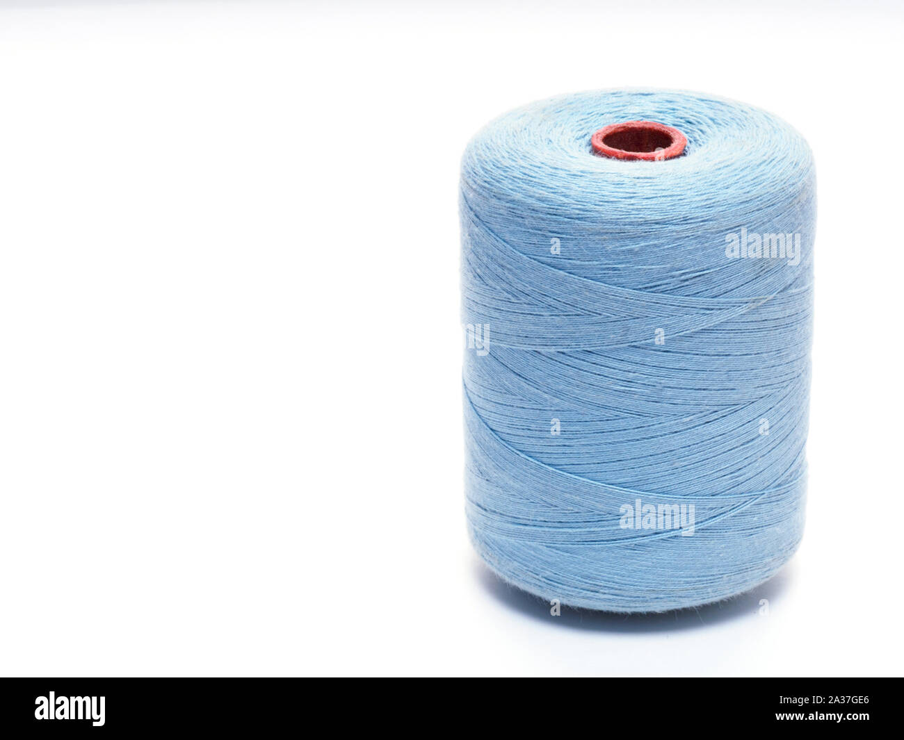 Blue spool of thread in a vertical position on a white background Stock ...