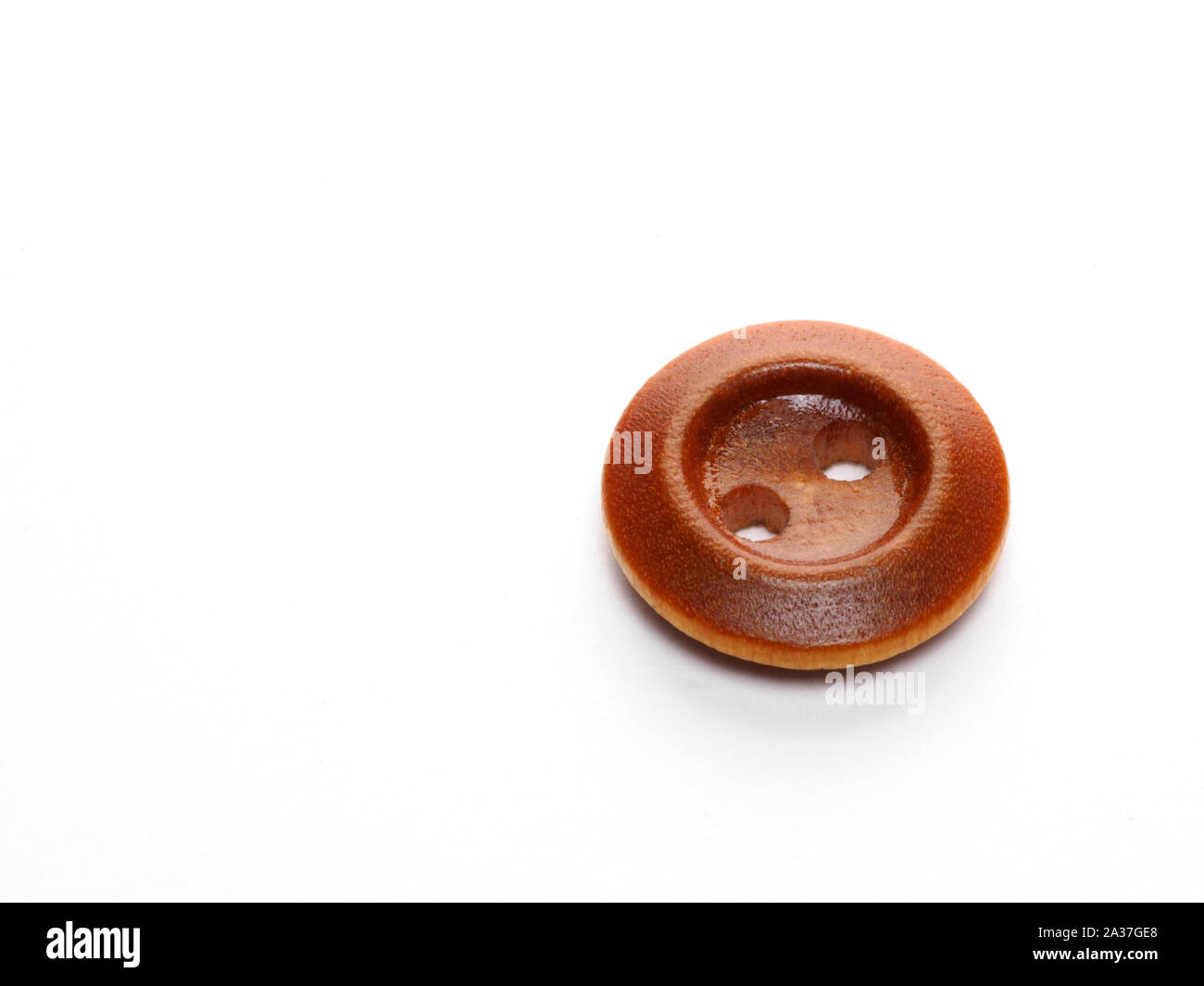 Brown wooden button on white background Stock Photo - Alamy