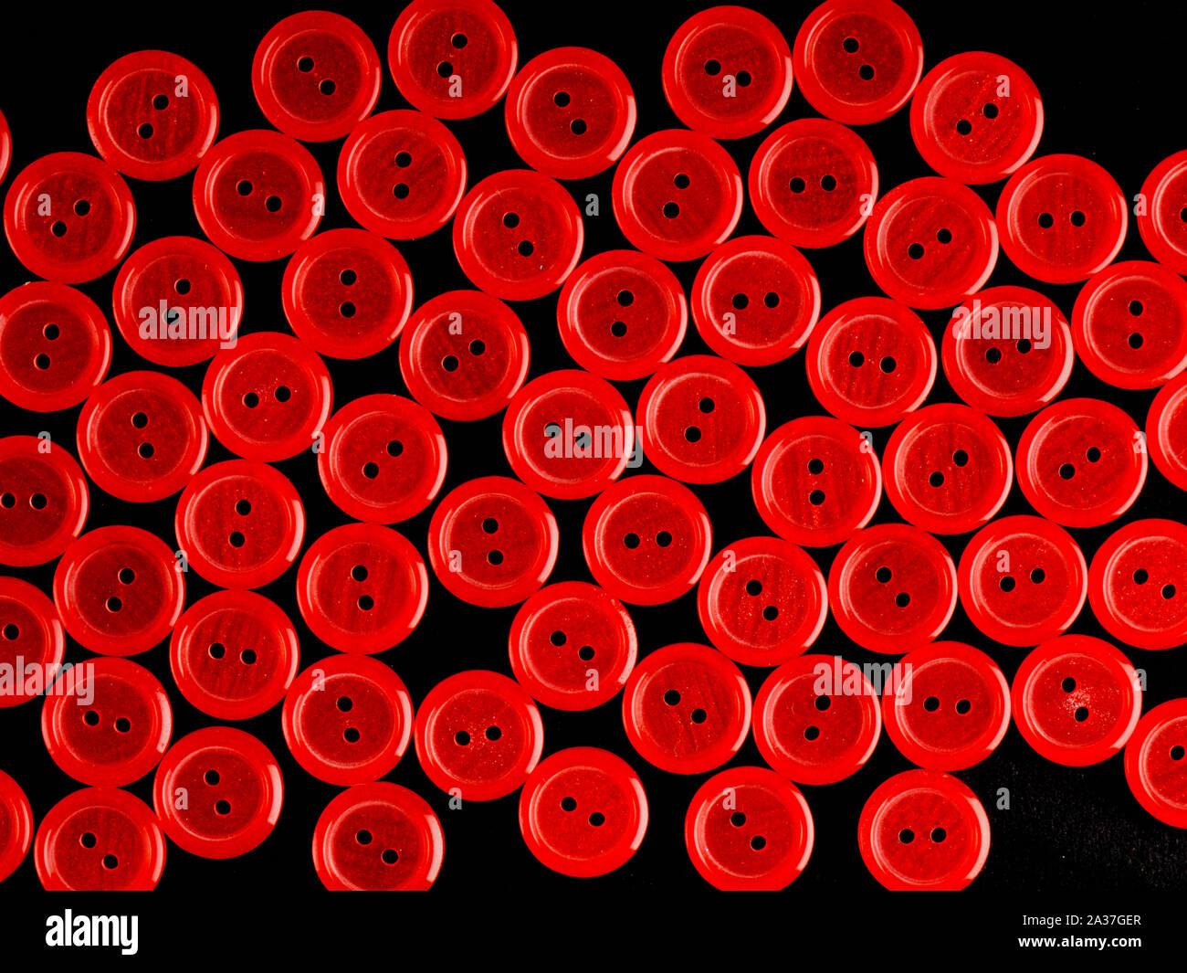 Red plastic buttons on black background Stock Photo - Alamy