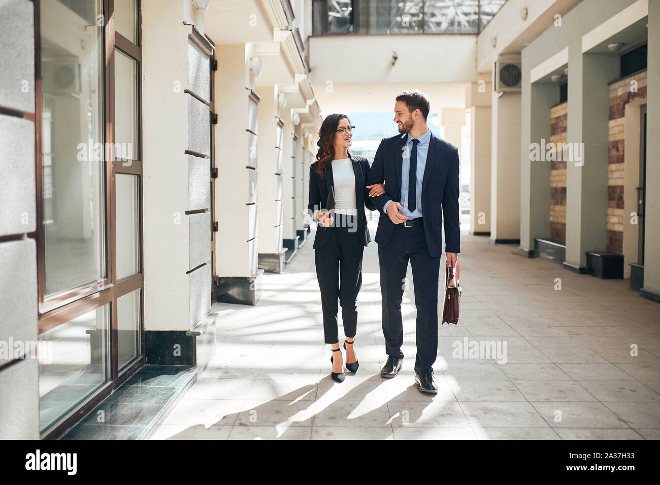 young man and woman talking about their fist day at the office, full ...