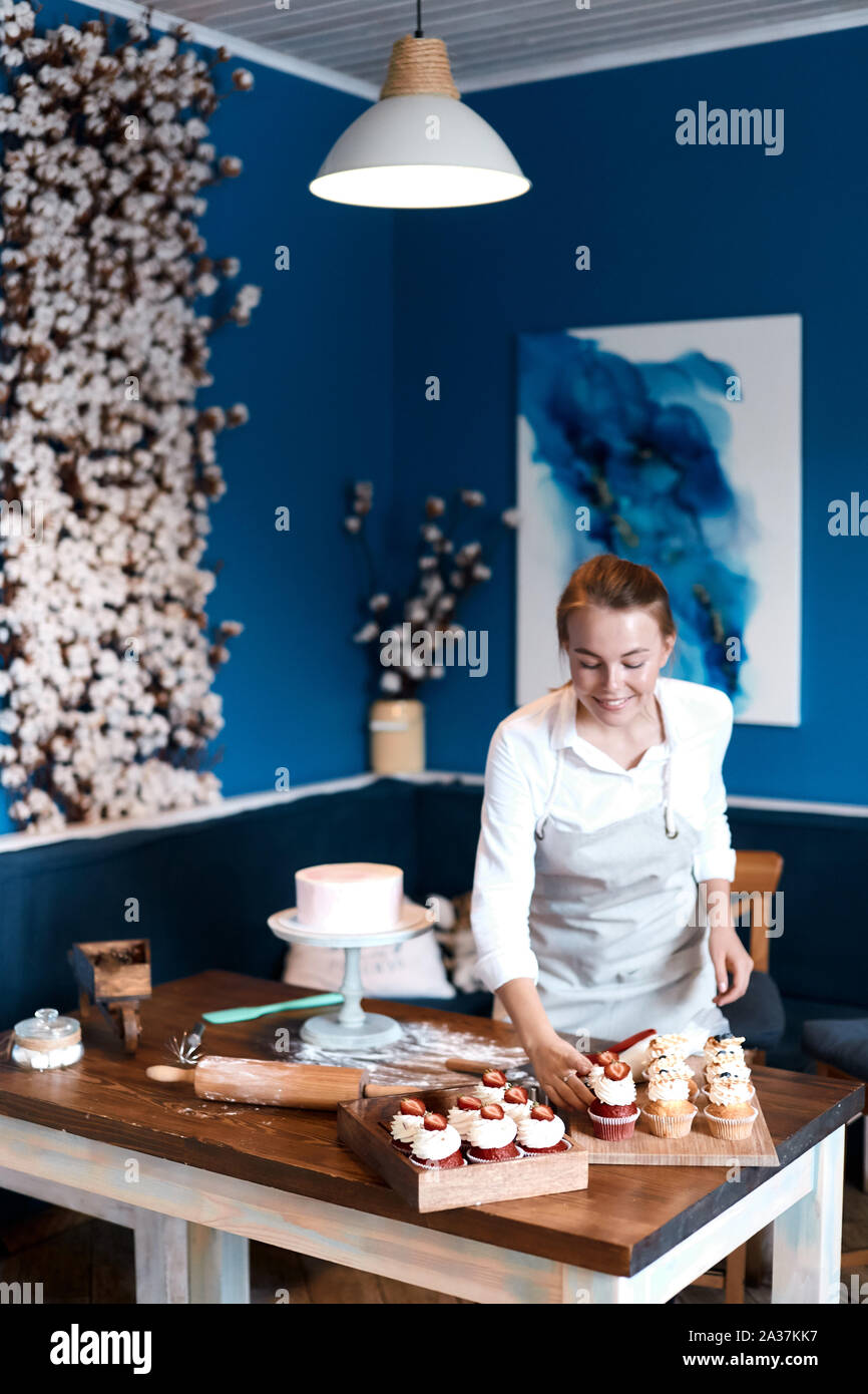 positive talented chef is decorating delicious muffins.close up photo ...
