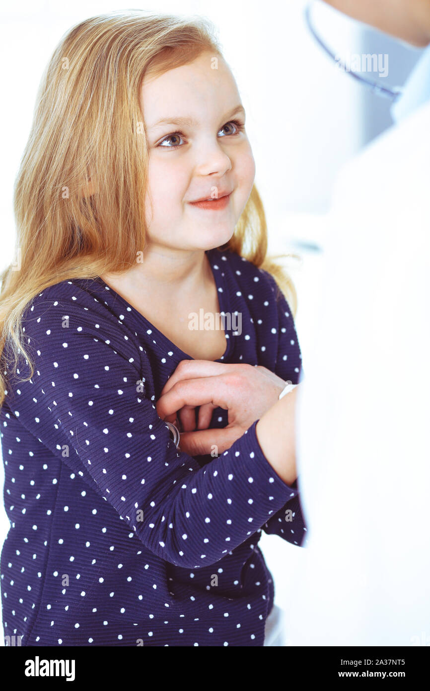 Doctor examining a child patient by stethoscope. Cute baby girl at ...