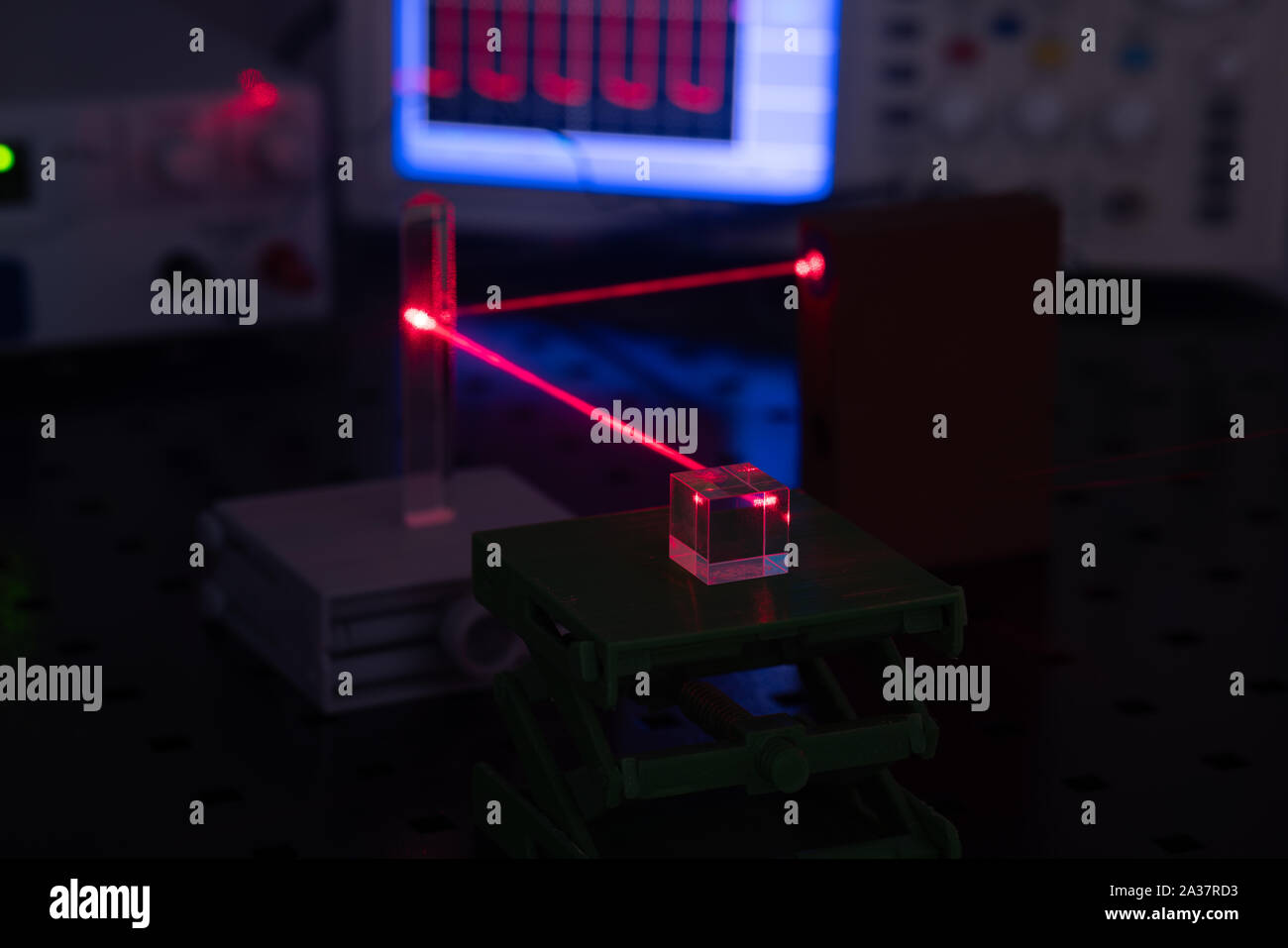 Experiment in optic lab with laser device. Red laser on optical table ...