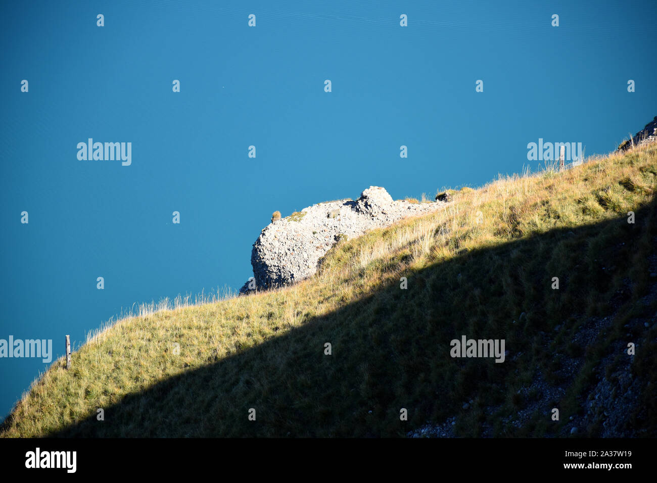 An oval shaped rock viewpoint on a hillside in the sun with Lake Zug in ...