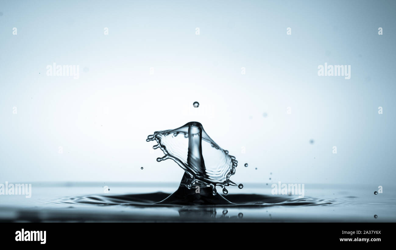 Close-up of a water drop falling on water surface Stock Photo - Alamy