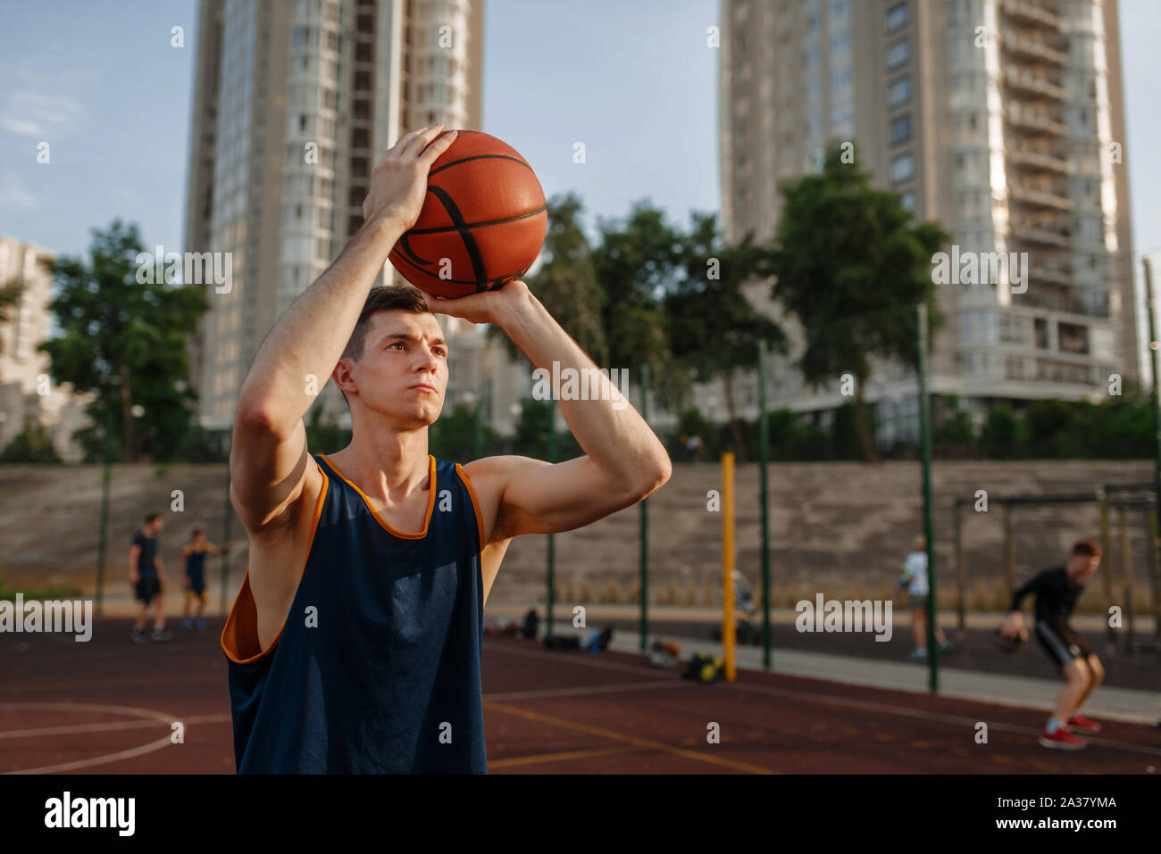 Basketball player makes a throw on outdoor court Stock Photo - Alamy