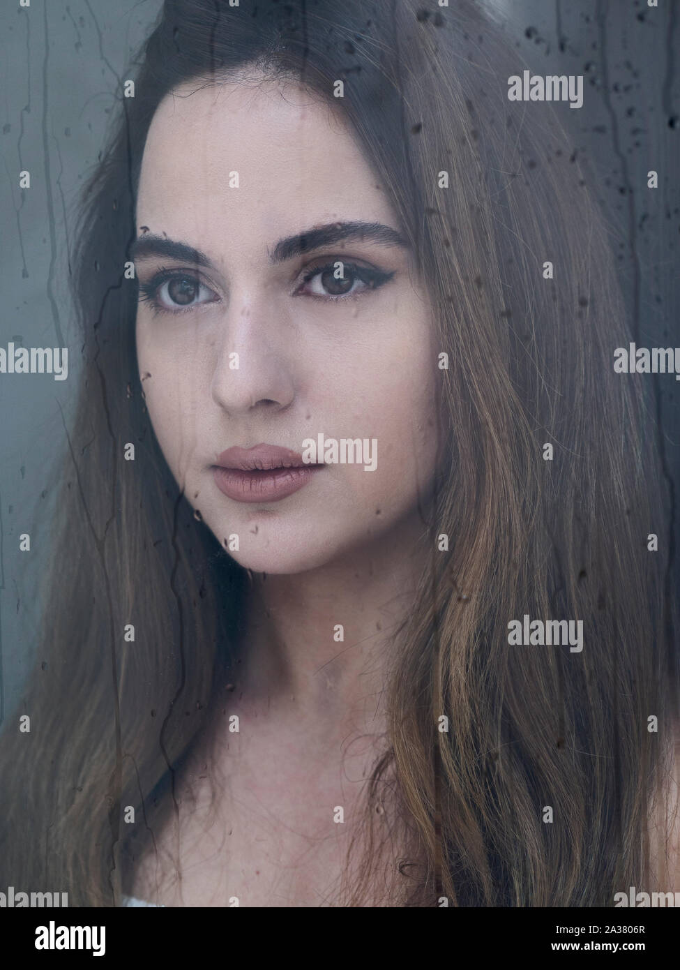 Woman looking through window rain hi-res stock photography and images ...