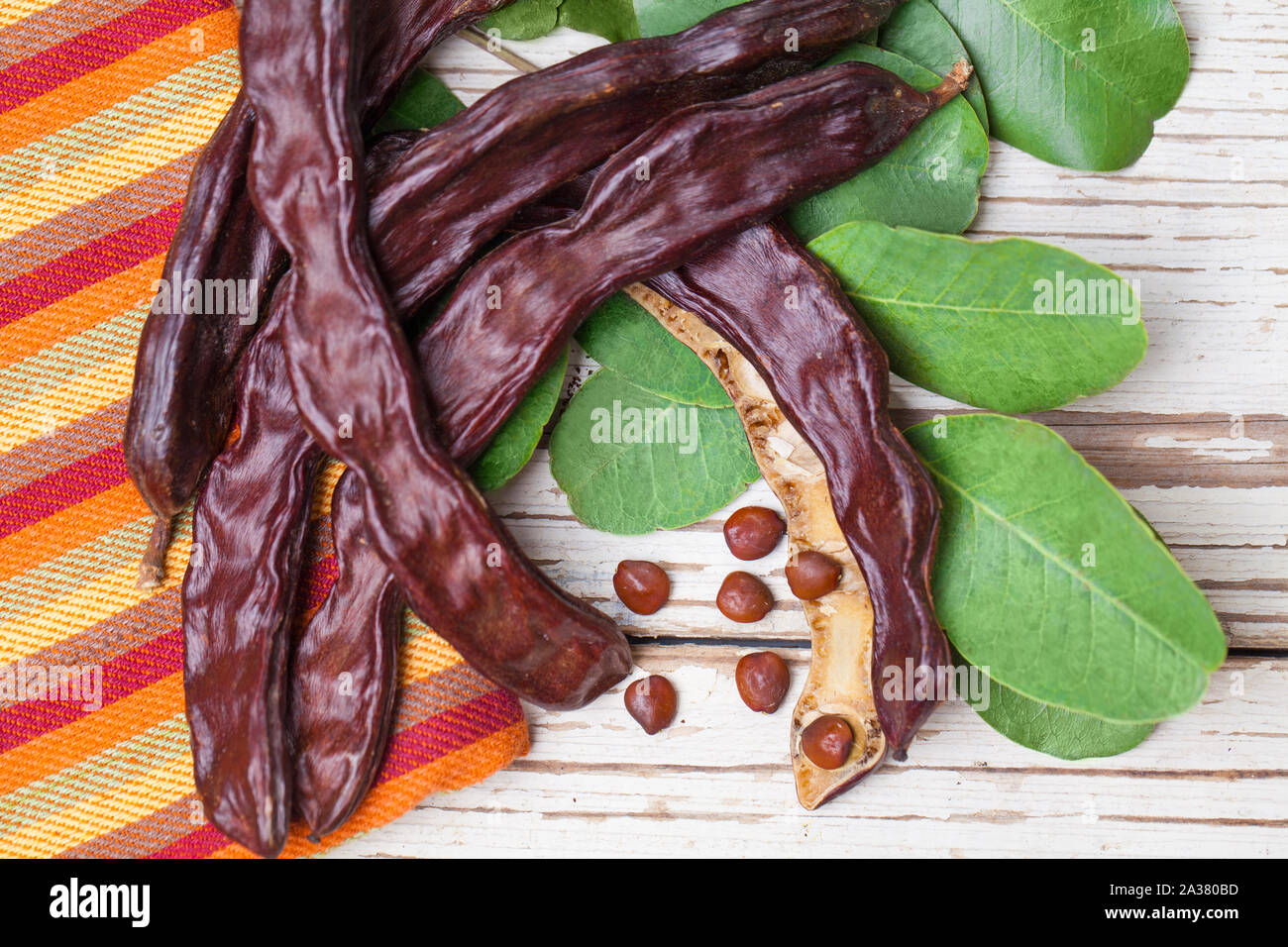Carob with powder. Organic carob pods with seeds and leaves on white ...