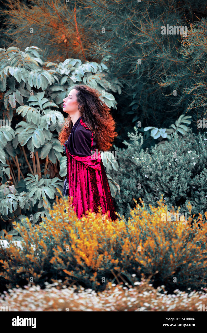 Beautiful young woman wearing a cloak in nature Stock Photo - Alamy