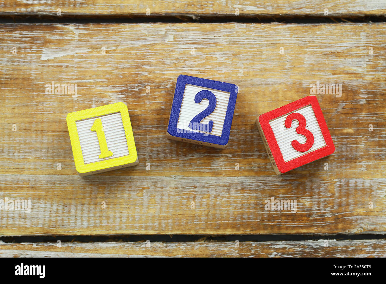 Three wooden blocks with colorful numbers 1, 2 and 3 written on them ...