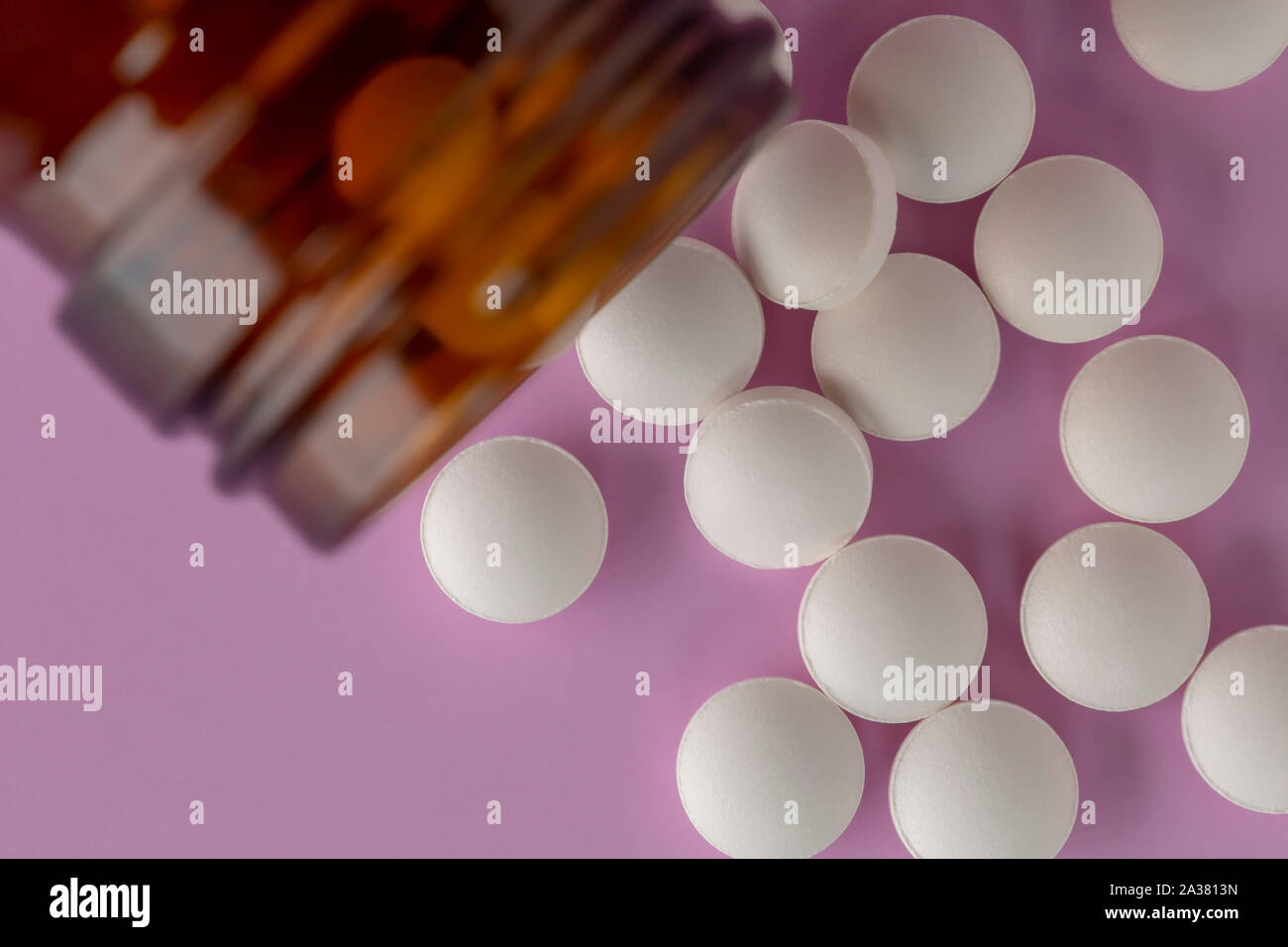White round drugs scattered around a glass bottle of medicine Stock ...