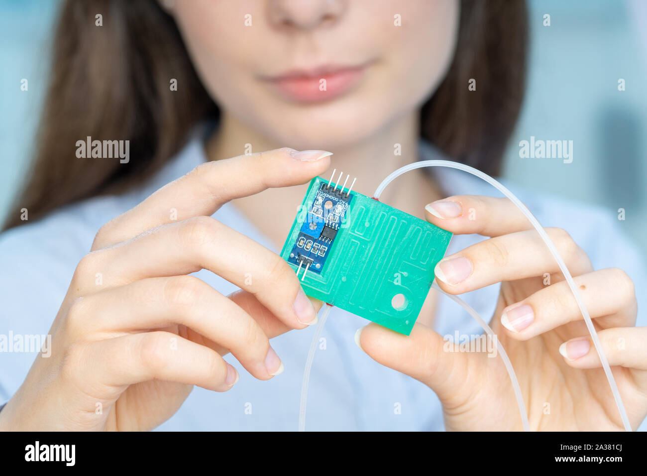 Young scientist woman in microbiological lab with lab-on-chip LOC ...