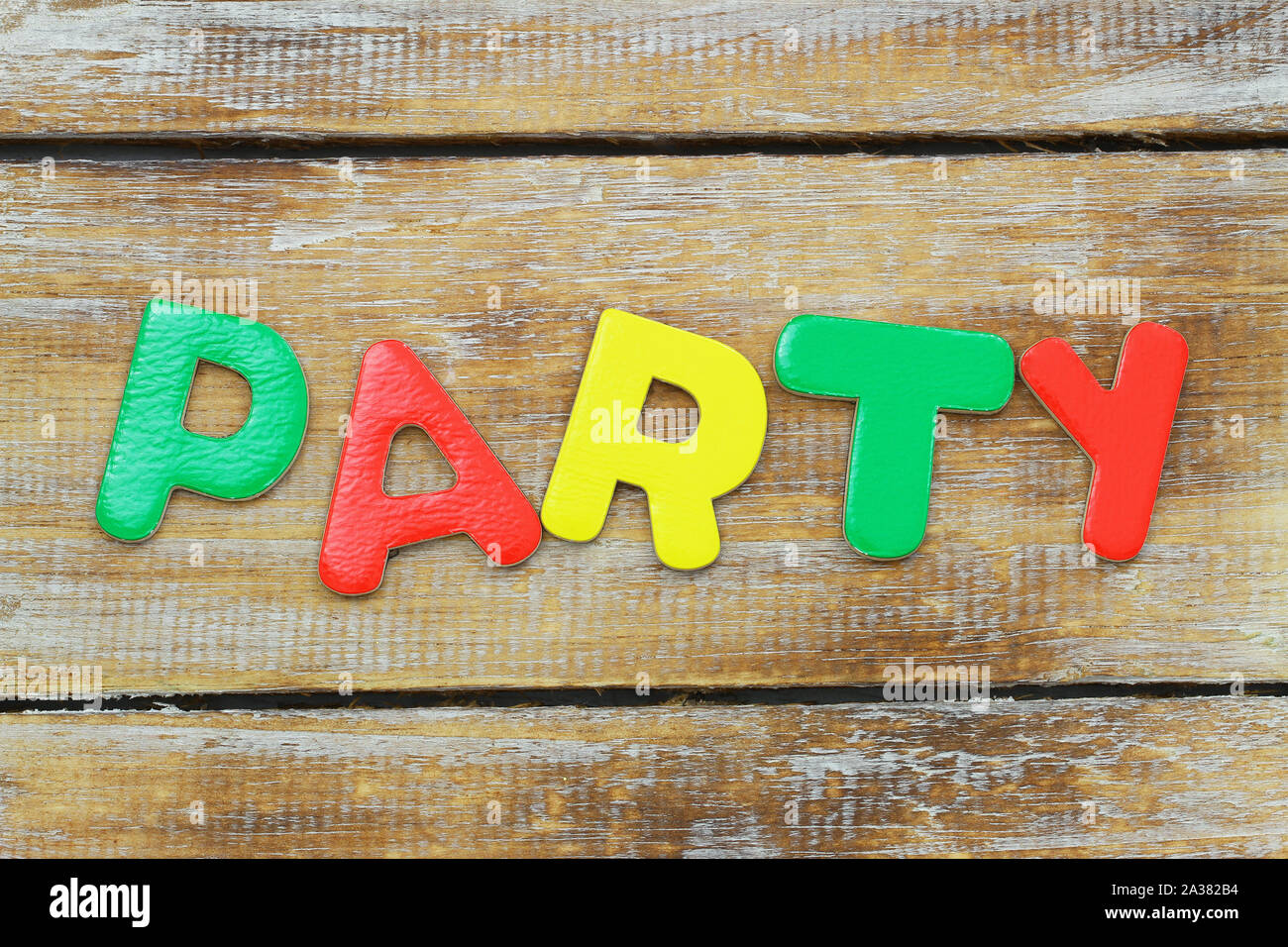 Word party written with vivid, colorful letters on rustic wooden ...