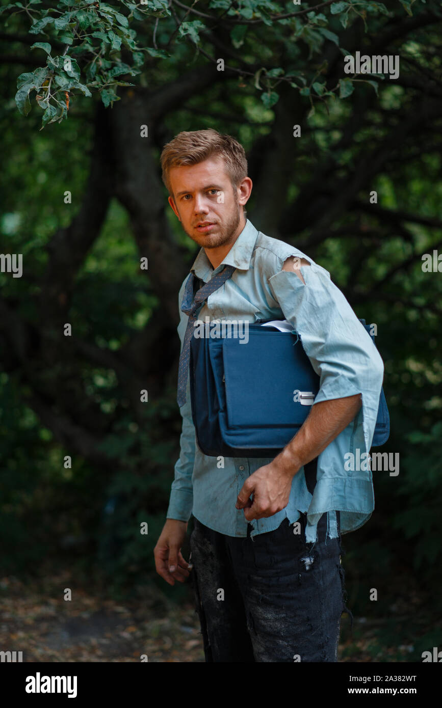 Businessman in torn suit walking on desert island Stock Photo - Alamy