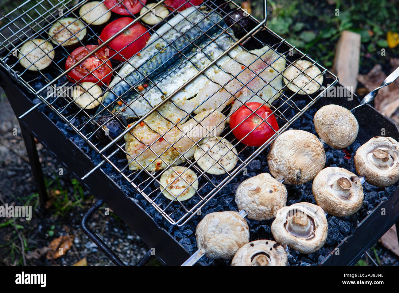 bbq concept fish on fire with mushroom and tomatoes Stock Photo - Alamy
