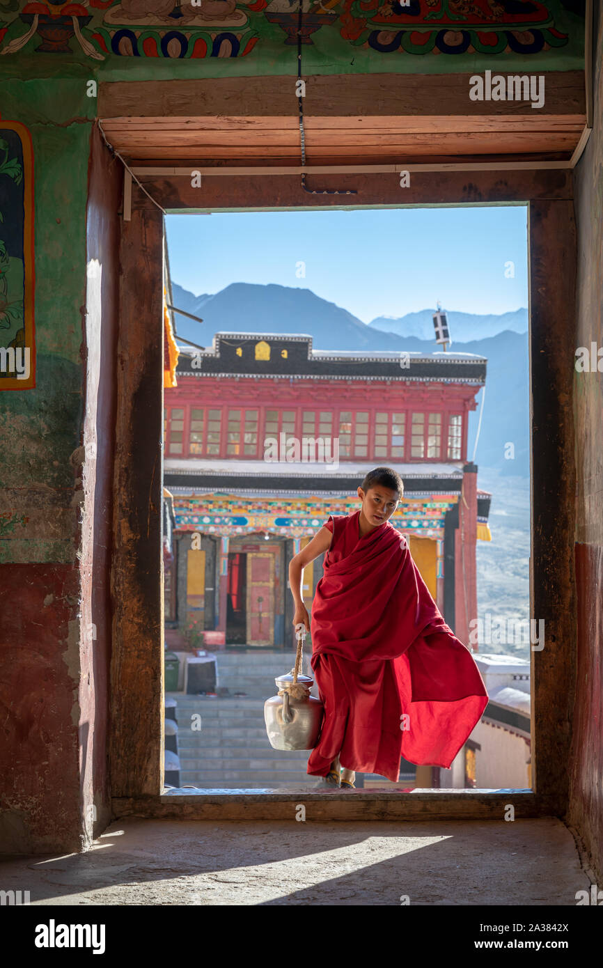 A young monk going through a door at Thiksey Monastery, Ladakh, Jammu ...