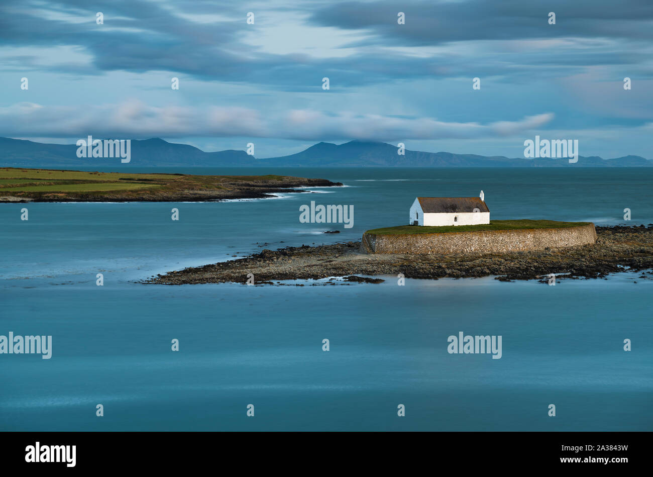 A moody sunset at the historic St Cwyfan's Church, Anglesey, located on ...