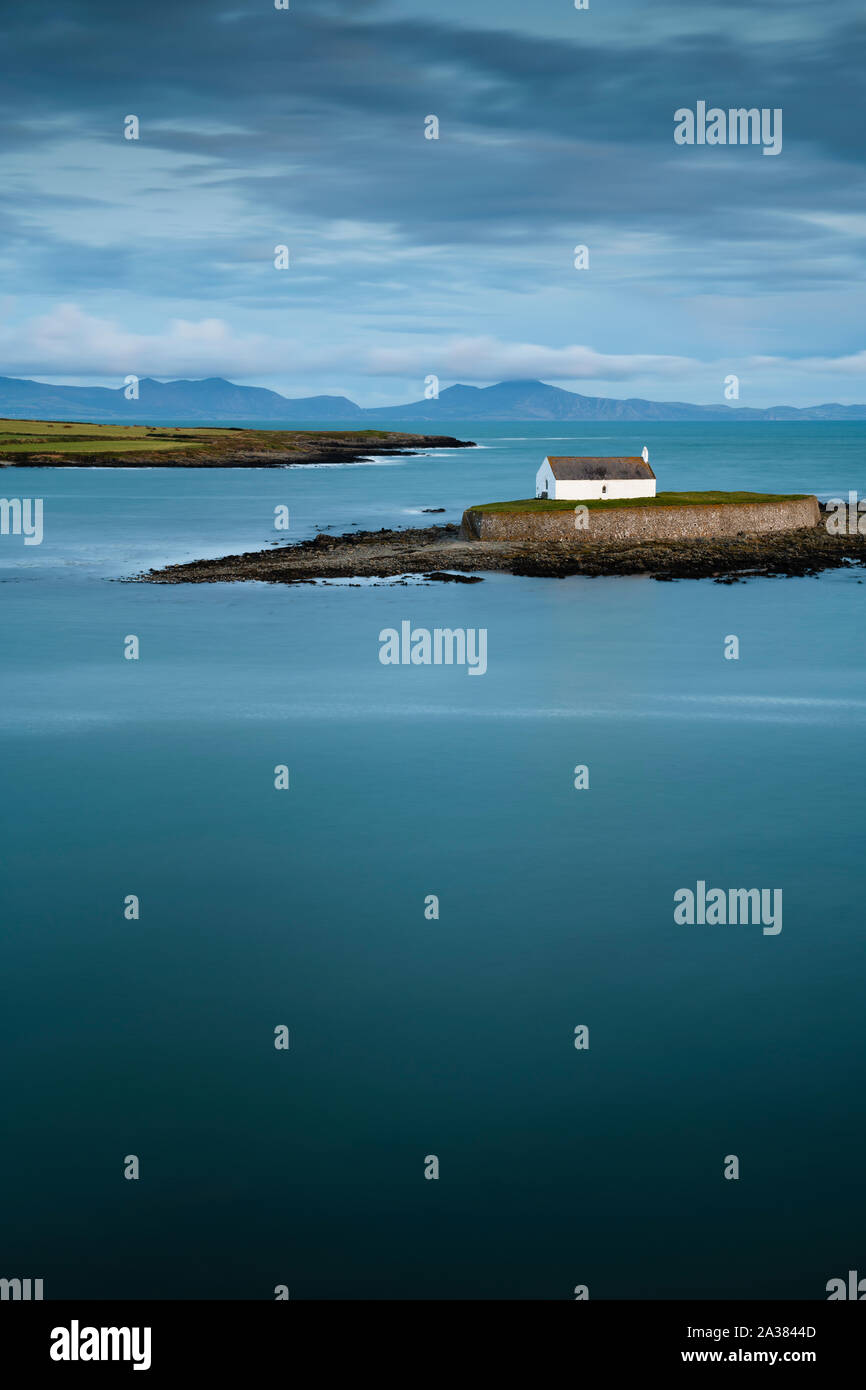 A moody sunset at the historic St Cwyfan's Church, Anglesey, located on ...