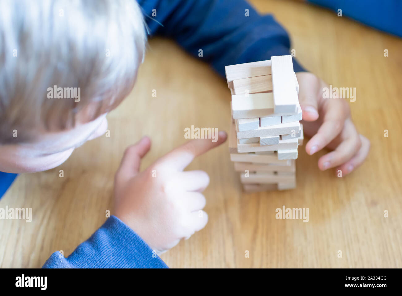 Close up couple playing jenga indoor on table.Boy lying down and playng ...
