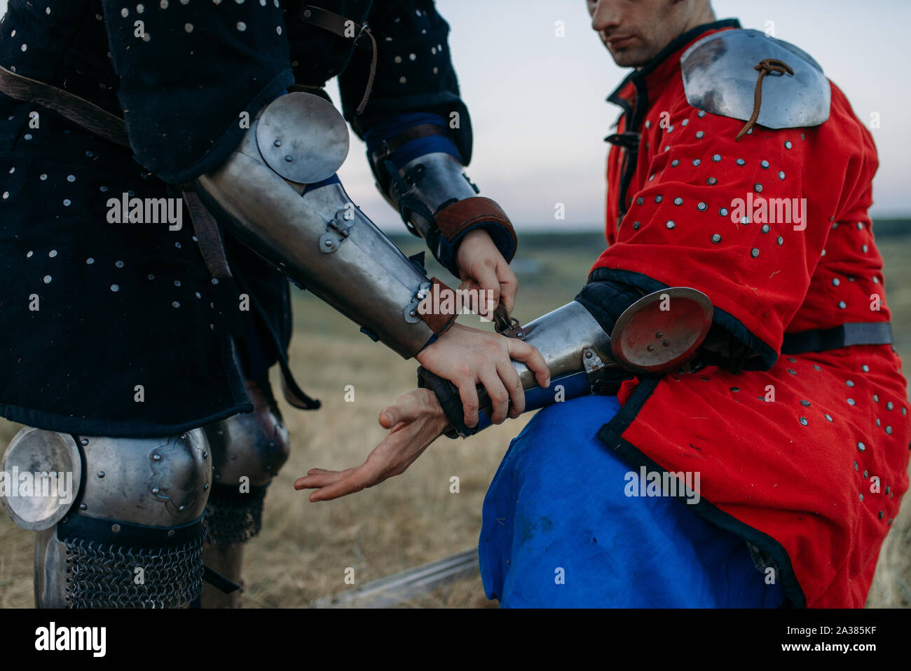 Medieval knight helps his friend to put on armor Stock Photo - Alamy