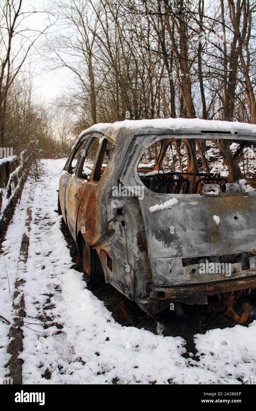 a burnt out car wreck in the snow Stock Photo - Alamy