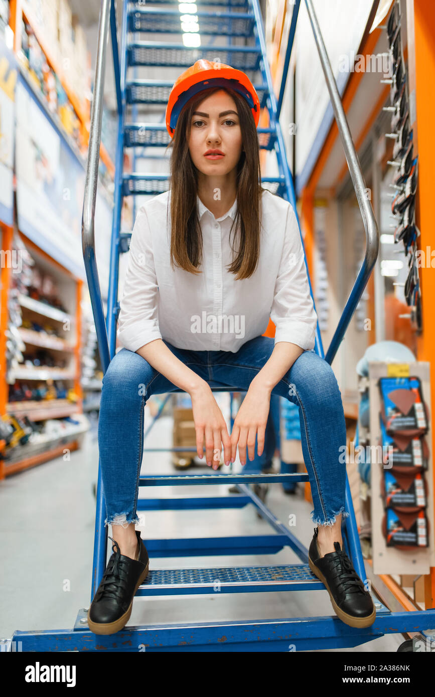 Female customer sitting on stairs, hardware store Stock Photo - Alamy