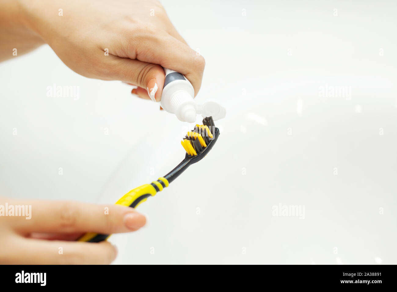 Close Up hands woman press toothpaste onto toothbrush Stock Photo - Alamy