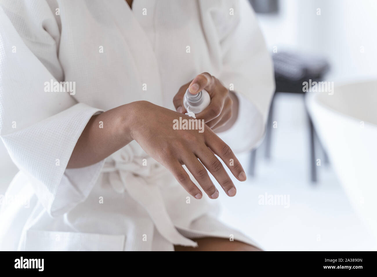 Young woman moistening skin of her hands Stock Photo - Alamy