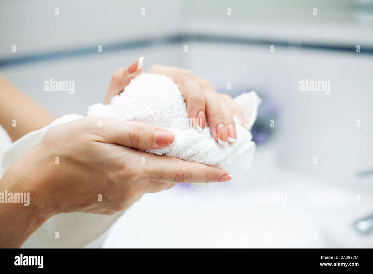 Hygiene and hand care. Woman using towel for wiping hands dry after ...