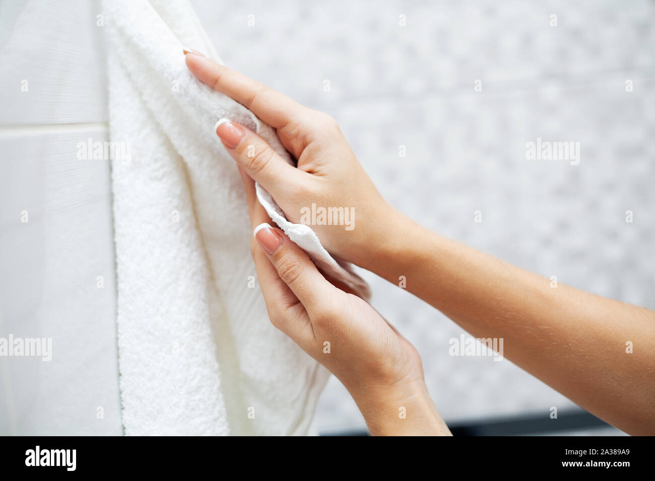 Hygiene and hand care. Woman using towel for wiping hands dry after ...