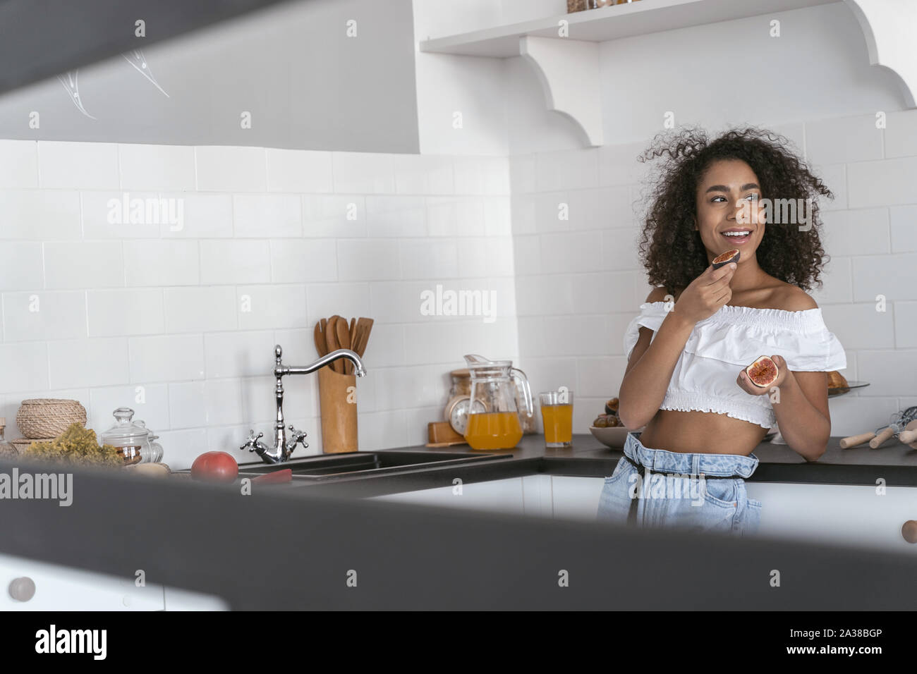 Beautiful woman taking a bite during cooking Stock Photo - Alamy
