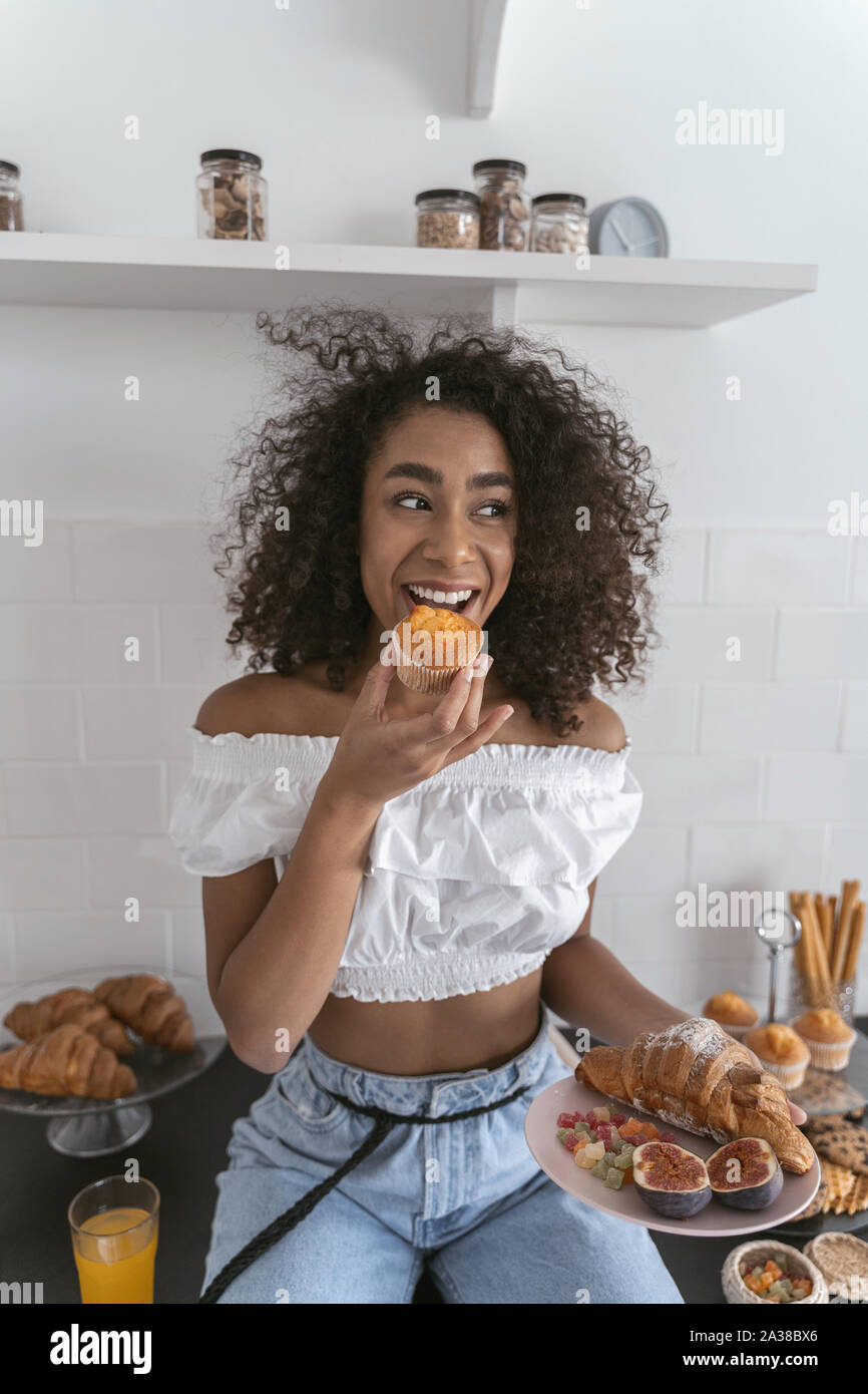 Cheerful girl eating sweets during her break Stock Photo - Alamy