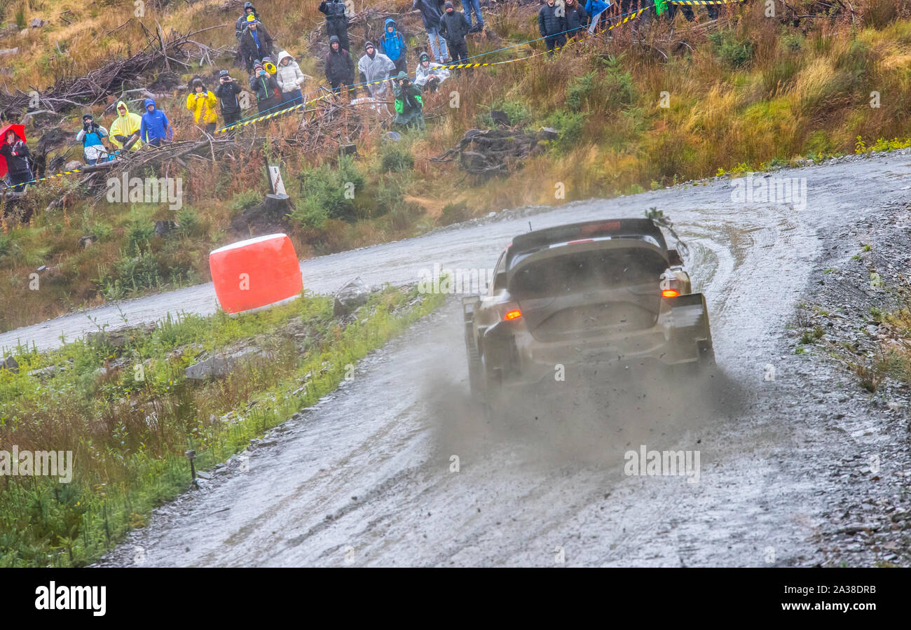A Toyota Yaris World Rally Car enters a corner at speed in front of a ...