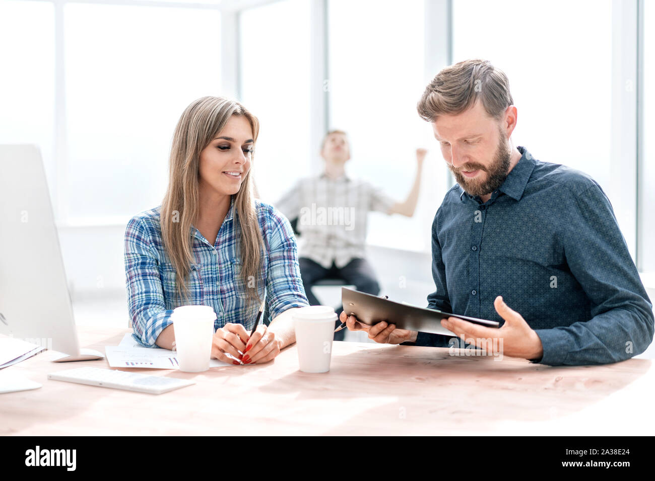 young employees sitting at a Desk in the office Stock Photo - Alamy