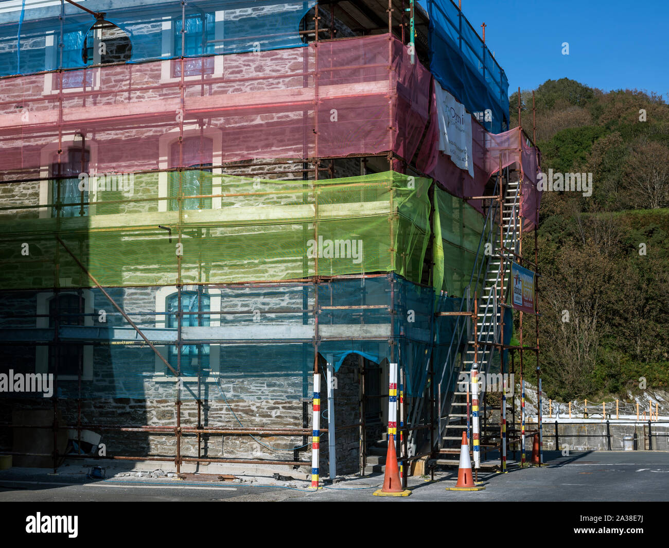 Scaffolding around three storey building covered in multicoloured ...