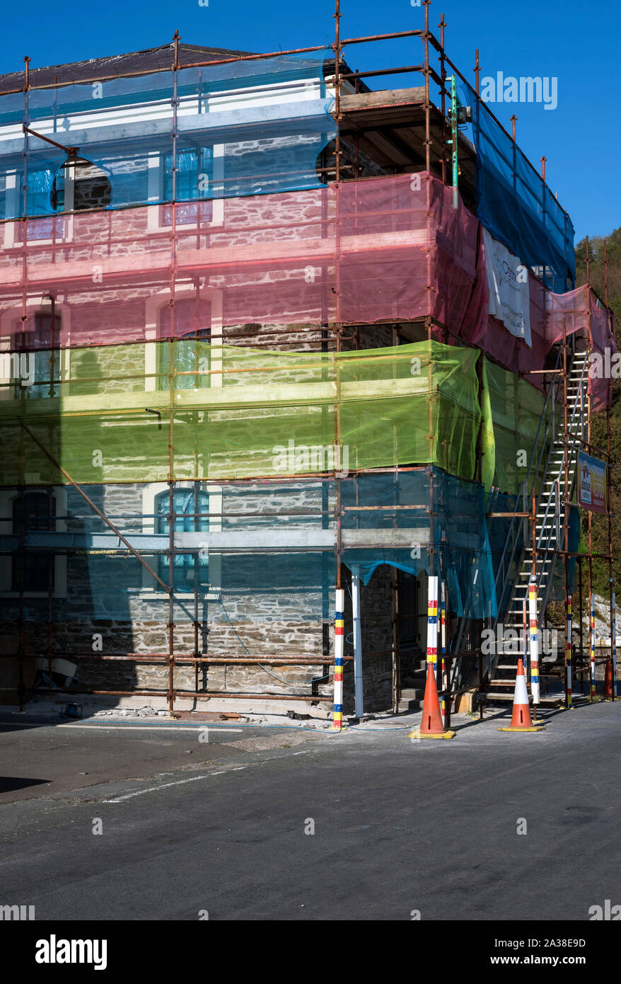 Scaffolding around three storey building covered in multicoloured ...