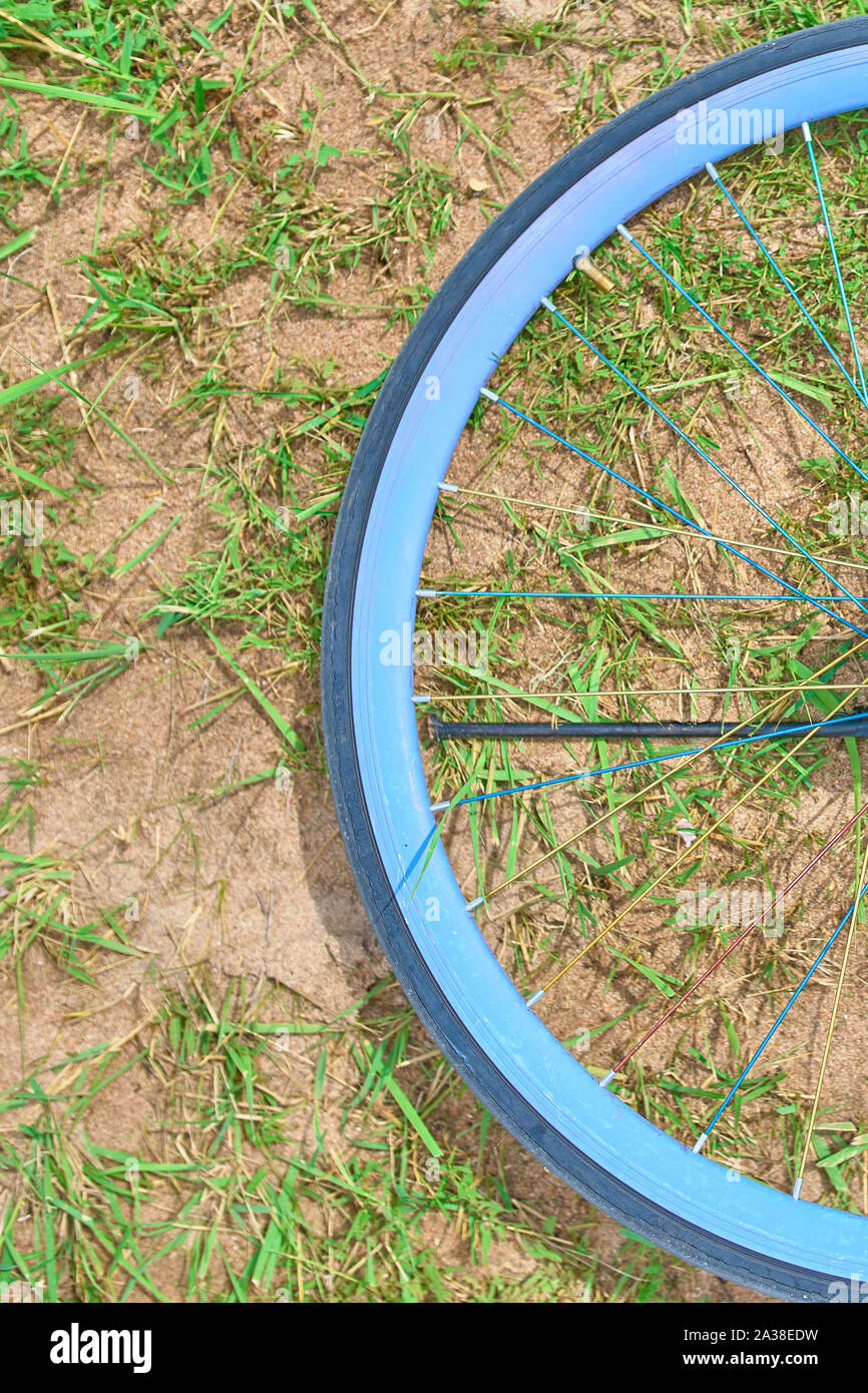 Part of the Bicycle wheel on the grass with sand Stock Photo - Alamy