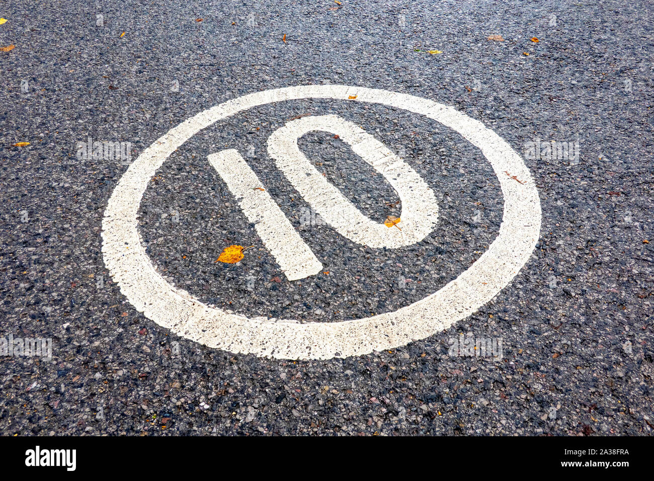 10 mile per hour speed limit sign painted in white on asphalt road ...