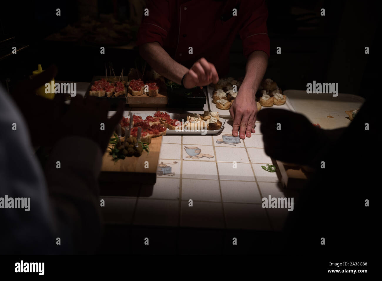 Three people standing by a selection of canapes Stock Photo - Alamy