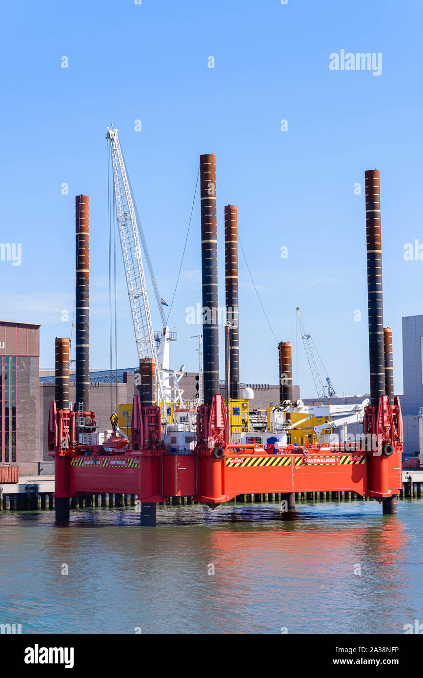A floating construction barge with a bucket grab and crane, has four of ...