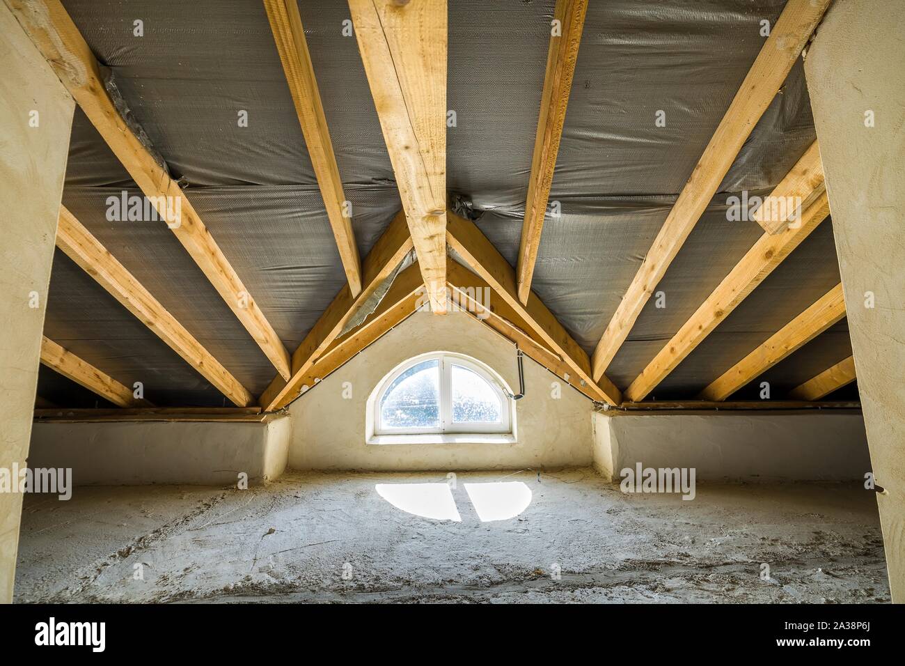 Attic of a building with wooden beams of a roof structure and a small ...