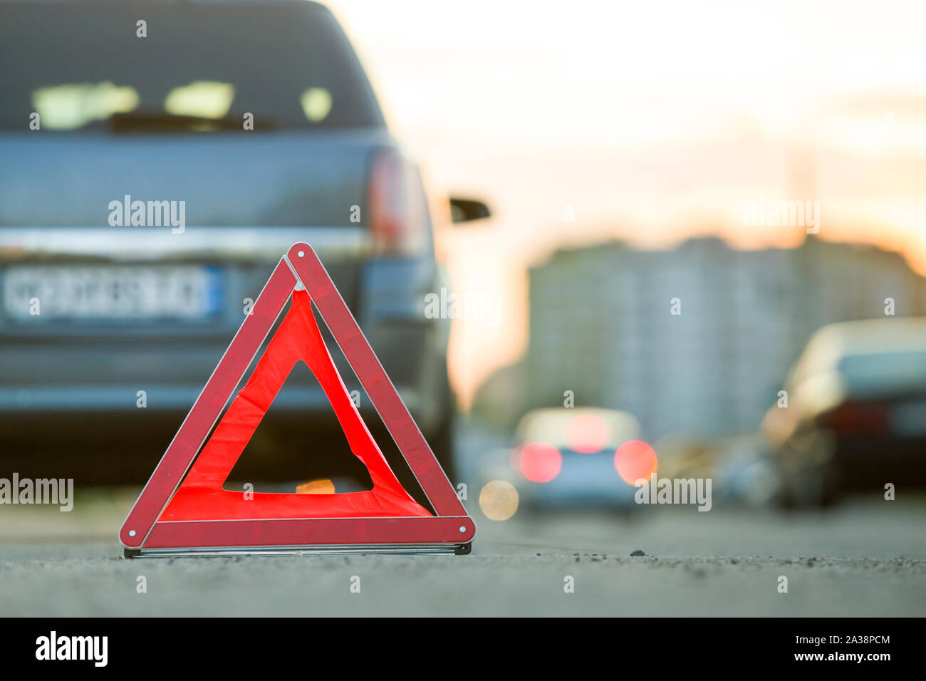 Red emergency triangle stop sign and broken car on a city street Stock ...