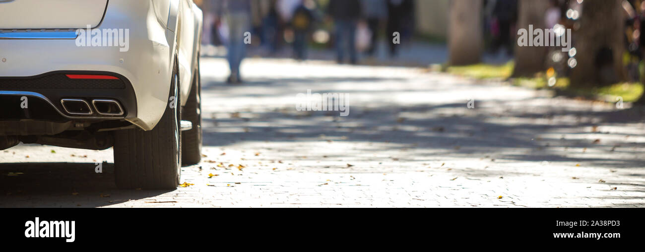 Back view of white car parked on city pedestrian zone on background of ...