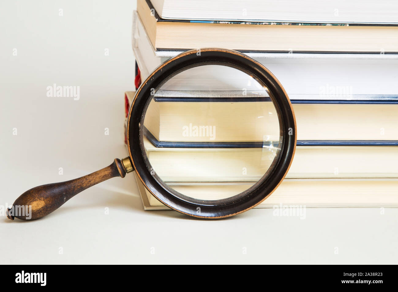 Books and the magnifying glass on wooden background Stock Photo - Alamy