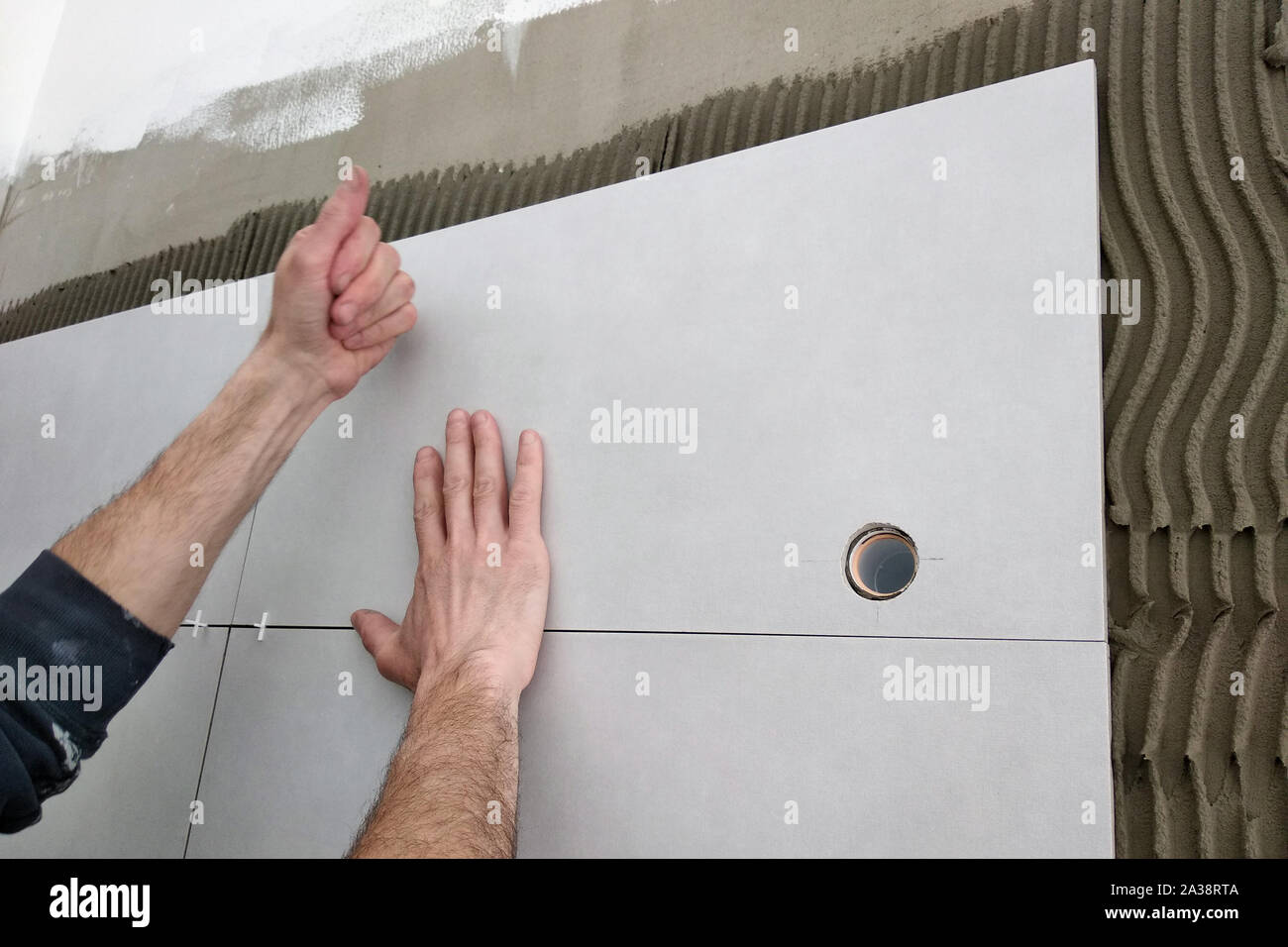 Worker hands putting ceramic tiles on the wall Stock Photo - Alamy