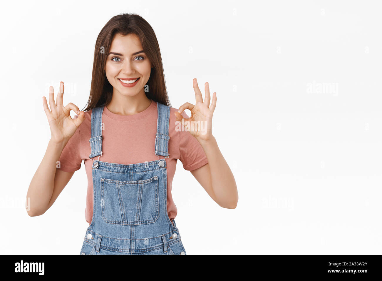 Confident, assertive good-looking woman in denim overalls, t-shirt ...