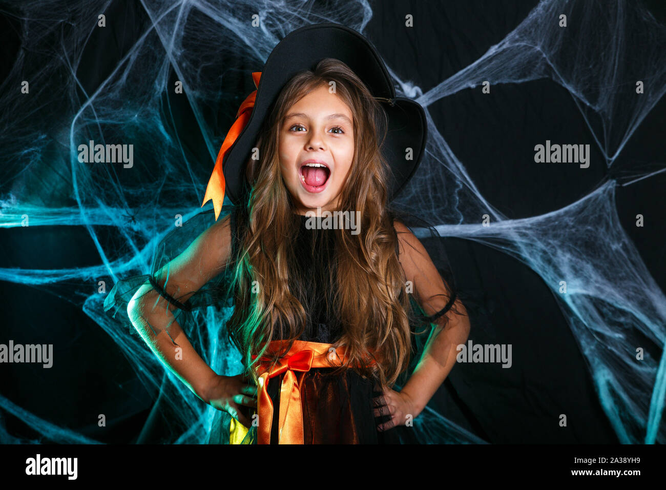 Halloween Witch concept - little witch child having fun over spider web ...