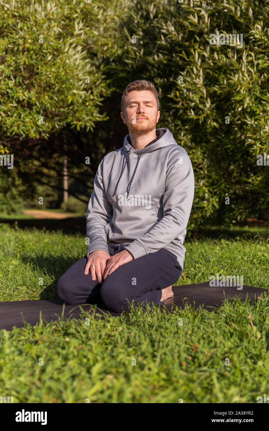 Inspired man doing yoga asanas in city park. Fitness outdoors and life ...