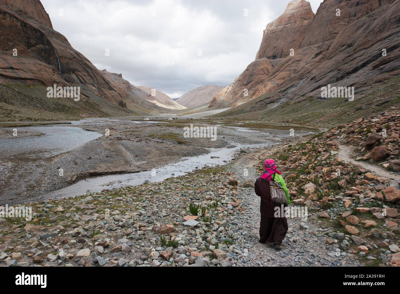 A pilgrim walks into Lha-chu valley on the path around Mount Kailash in ...